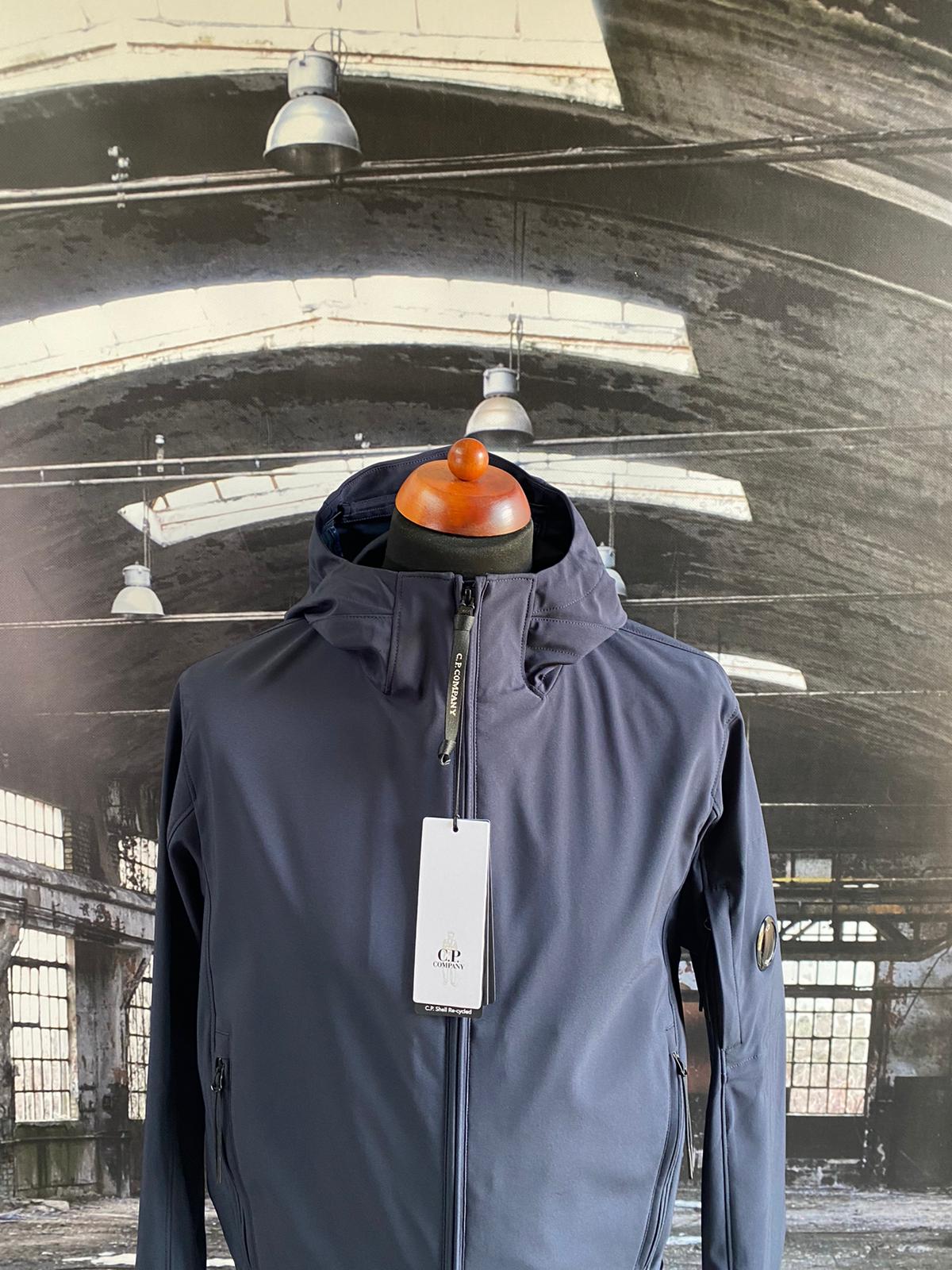 C.P. COMPANY LENS SOFT SHELL R HOODED JACKET - X Clothing